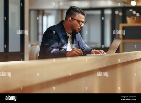 Graphic Designer Working On A Laptop In A Coworking Office Creative
