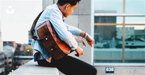 청록색 드레스 셔츠와 검은 바지를 입고 갈색 어쿠스틱 기타를 연주하는 남자 사진 Unsplash의 무료 포트웨인 이미지