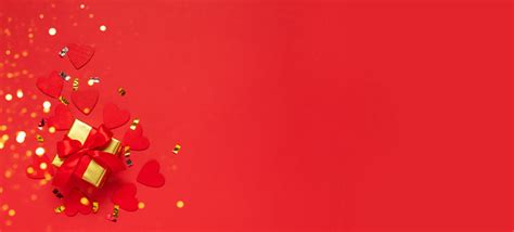 반짝이는 하트와 색종이가 있는 붉은 색 배경에 빨간 활이 있는 선물 발렌타인 데이 새해 어머니의 날 결혼식을위한 축제 플랫 구성 복사 공간을 가진 모형 0명에 대한 스톡