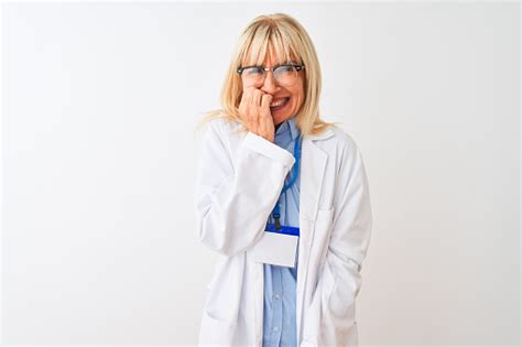 중년 과학자 여성은 안경을 착용하고 고립 된 흰색 배경 위에 신분증을 쓰고 입에 물린 손톱에 손을 대고 긴장하고 있습니다 불안 문제 감정에 대한 스톡 사진 및 기타 이미지