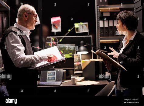 Senior Police Officer Checking Crime Evidence Discussing Criminology Report With Fbi Agent