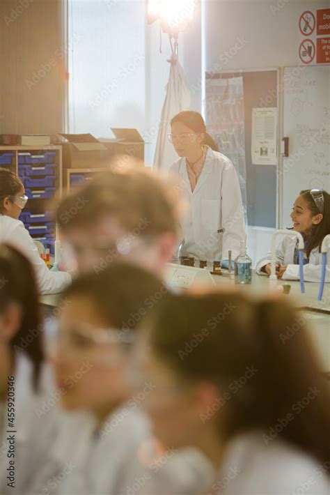 Female Teacher And Babes Conducting Scientific Experiment In Laboratory Classroom Stock Photo