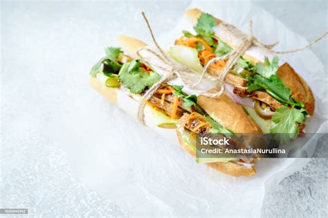 클래식 반 미 샌드위치와 구운된 돼지고기 안심 슬라이스 당근 및 벗 겨 오이 Jalapeno 고추 실 란 트로 흰색 질감 배경 났습니다 상위 뷰 복사 공간 Bánh Mì