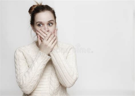 A Young Pretty Girl With Big Eyes Covered Her Mouth With Her Han Stock