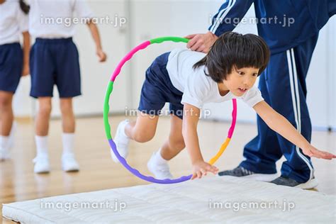 フラフープをくぐる小学生の男の子の写真素材 [205160641] イメージマート