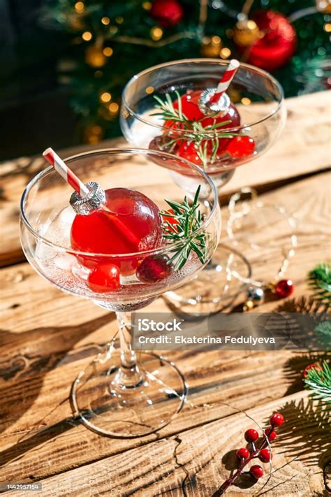 크리스마스 다과 음료 미모사 펀치 또는 크랜베리 마가리타 칵테일은 크리스마스 장식품과 마티니 마시는 안경에 제공됩니다 크리스마스와 겨울 휴가 파티를위한 맛있는 얼음 음료