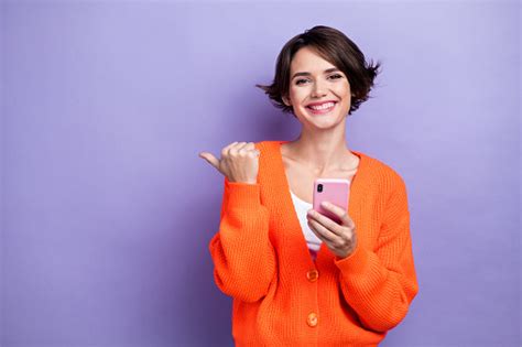 긍정적 인 단 여자 입고 오렌지 카디건 타이핑 현대 가제트 엄지 손가락 빈 공간 외딴 보라색 배경의 사진 25 29세에 대한 스톡 사진 및 기타 이미지 Istock