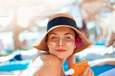 얼굴에 썬 크림을 가진 젊은 여자는 해변에서 Sun스크리 엔 병을 들고 피부에 보습 로션을 바르는 모자입니다 햇볕 차단 로션에 대한 스톡 사진 및 기타 이미지 Istock