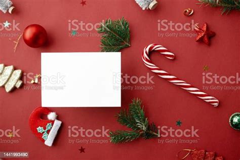 크리스마스 카드 모형 빨간색 배경 플랫 레이에 크리스마스 장식이 있는 현대적인 인사말 카드 구성 텍스트를 위한 공간이 있는 빈
