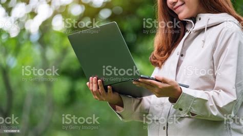 야외에서 노트북 컴퓨터를 들고 사용하는 여성 35 39세에 대한 스톡 사진 및 기타 이미지 35 39세 개념 노트북 Istock