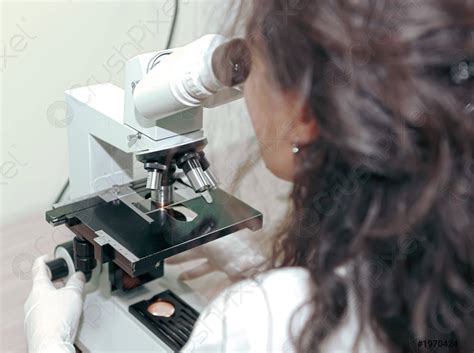 Female Lab Technician Analyzing Sample Through Microscope Medical Tests Relate Stock Photo