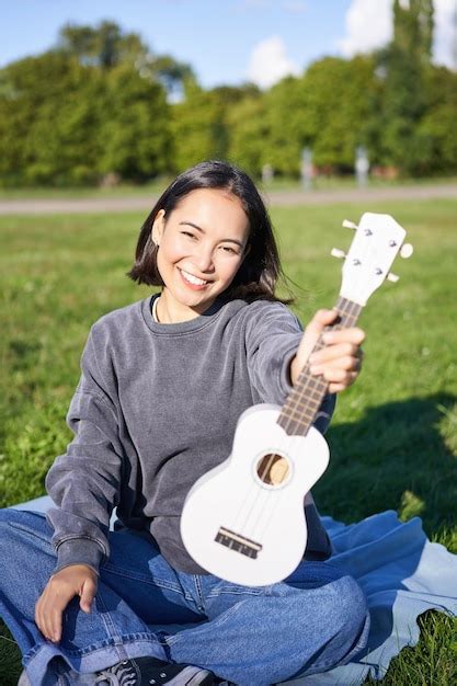 Premium Photo Music And Instruments Smiling Asian Girl Shows Her