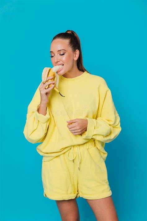 A Woman In Yellow Clothes Eats A Banana Stock Image Image Of Peanut Abstract
