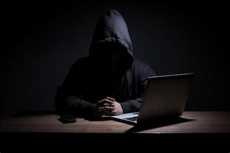 Premium Ai Image Hacker Wearing Black Hoodie Using Laptop Computer