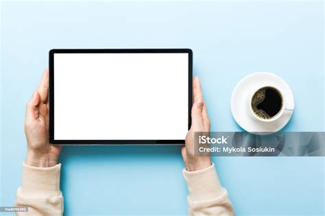 커피 한 잔과 함께 문자 메시지 또는 홍보 콘텐츠 옴 테이블에 대한 빈 복사 공간 화면이 있는 디지털 태블릿을 들고 있는 이미지 여자 손을 닫습니다 빈 태블릿 장치를 들고
