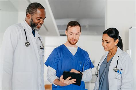 병원 연구 시설에서 원격 건강 디지털 결과 또는 온라인 의료 정보 데이터를위한 태블릿을 사용하는 의사 및 간호사 의료 종사자 그룹 기술 소프트웨어 앱을 사용하는 사람과 여성