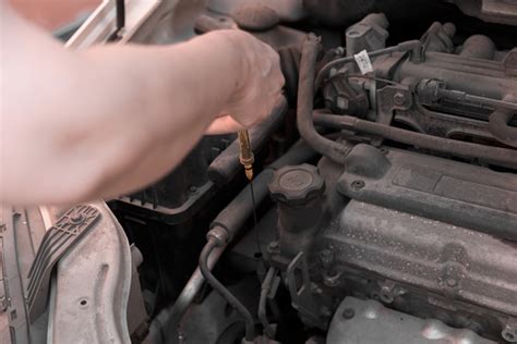 한 여성의 손이 딥스틱을 꺼내 자동차 엔진의 오일 레벨을 확인합니다 걱정하는에 대한 스톡 사진 및 기타 이미지 걱정하는