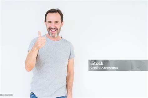 행복 한 엄지손가락 손으로 제스처를 하 고 격리 된 배경 위에 잘생긴 수석 남자 승인 성공을 보여주는 카메라를 보고 하는 식