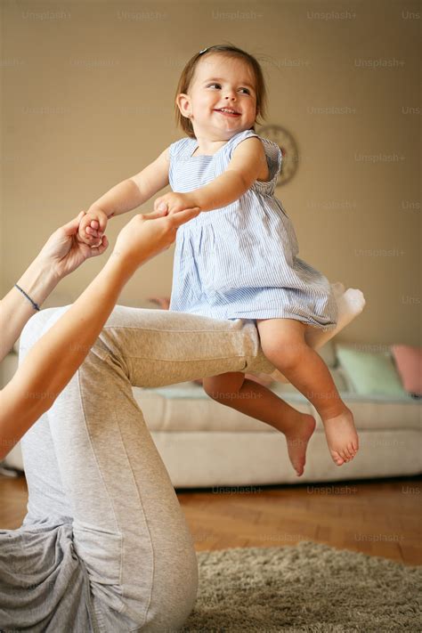 젊은 어머니는 바닥에서 딸과 놀고 있습니다 어머니는 작고 귀여운 아기와 함께 자유 시간을 즐기고 있습니다 엄마 다리에 앉아 있는 아기 사진 Unsplash의 초상 이미지