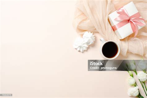 플랫 레이 홈 오피스 책상 스카프 커피 컵 선물 상자 마쉬 멜 로우와 분홍색 배경에 장미 꽃과 여성 작업 공간 텍스트에 대 한