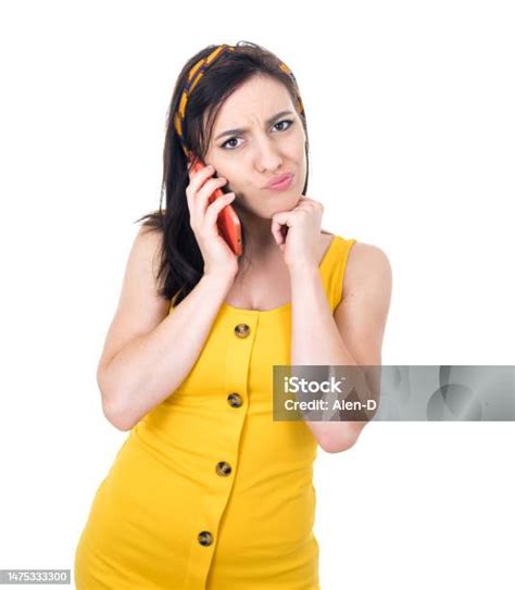 지루한 젊은 여자가 전화를 받고 찡그린 얼굴을 하고 흰색 배경에 고립되어 있다 짜증나는 여자 사람이 이야기합니다 스마트 폰에서 귀찮고 지루함 20 24세에 대한 스톡 사진