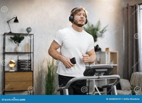 Close Up Portrait Of Handsome Muscular Man In White T Shirt Having Workout On His Electric