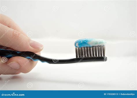Black Toothbrush With The Minty Color Of Toothpaste In The Girl`s Hand Stock Image Image Of