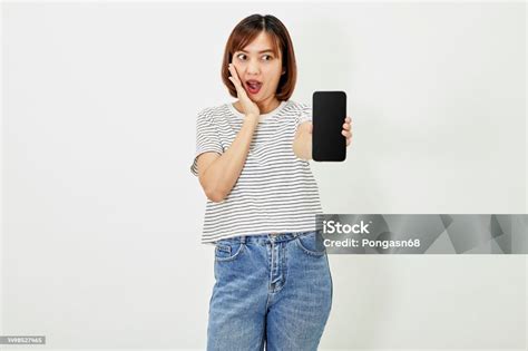 귀여운 아시아의 짧은 갈색 머리 여자는 스마트폰 앱을 홍보하고 개인 소셜 미디어 페이지를 보여주는 여성 블로거는 하얀 배경에 행복하게 웃고 있는 전화 카메라를 들고 있다