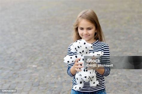 그녀의 새로운 장난감을 가지고 놀고 행복한 아이는 야외에서 장난감 개와 함께 놀아 게임 및 플레이 어린 시절 활동 유치원 및 놀이 학교 장난감 가게 아기를 즐겁게 하고