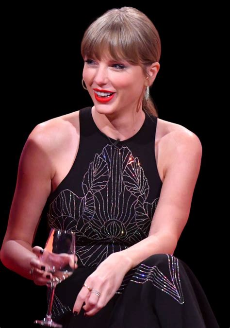 taylor swift holding a wine glass and smiling