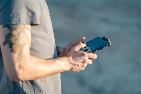 Young Man Using Drone Controller With Smart Phone Close Up Caption