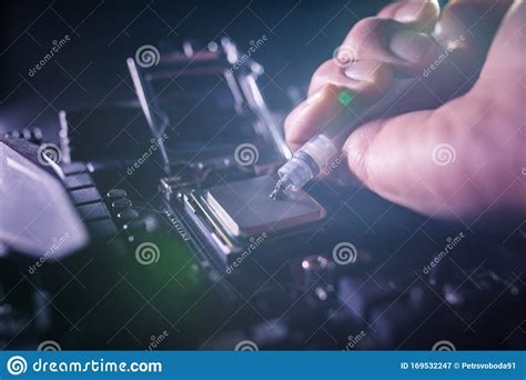 close up to technician squeezing or application the thermal paste compound on the top of main