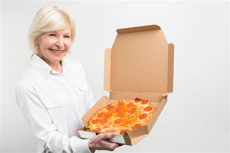 맛 있는 피자의 큰 상자를 들고 할머니의 컷 보기 그녀는 정크 푸드를 좋아한다 그것은 사람들을 위해 건강 하지 않습니다 여성은 즐겁고 행복 보인다 흰색 배경에 고립입니다