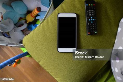 집의 소파에 모바일입니다 아기 장난감 및 원격 제어 참조 거실에 대한 스톡 사진 및 기타 이미지 거실 리모콘 휴대전화 Istock