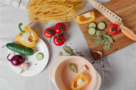 테이블에 야채와 원시 파스타 체리 토마토 노란 피망 오이 붉은 양파와 마늘이 칼을 들고 도마위에 올려보냅니다 요리용 재료 개념에 대한 스톡 사진 및 기타 이미지 Istock