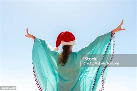 하늘까지 그녀의 손으로 해변에 서 서 산타 모자를 쓰고 여자 20 29세에 대한 스톡 사진 및 기타 이미지 20 29세
