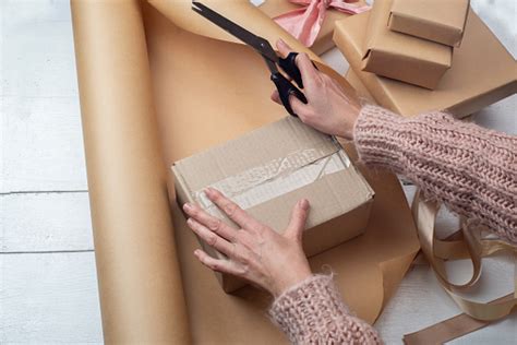 크래프트 페이퍼에 선물 포장 크래프트 페이퍼에 선물 포장 여성 손은 밝은 리본으로 만든 선물과 넥타이 활상자를 랩 개체 그룹에