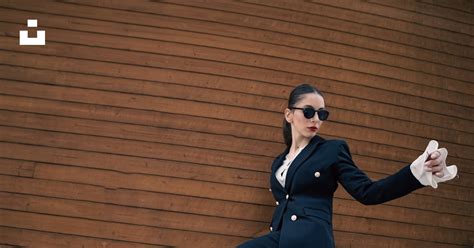 양복과 선글라스를 끼고 사진을 찍기 위해 포즈를 취하는 여성 사진 Unsplash의 무료 유행 이미지