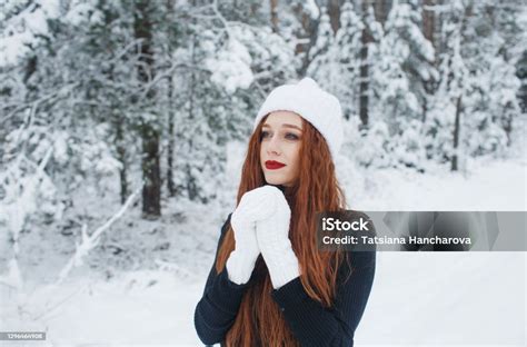 겨울 배경에 긴 빨간 머리를 가진 젊은 빨간 머리 소녀 겨울 자연의 배경에 흰색 모자를 입은 빨간 머리의 여성 겨울에 대한 스톡 사진 및 기타 이미지 Istock