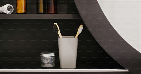 폐기물 제로 개념 플라스틱 무료 대나무 칫솔 유리에 숯 치약 피부를위한 Ubtan 컨디셔너 탈취제 검은 선반에 현대적인 욕실의 강장제 천연 필수품 사진