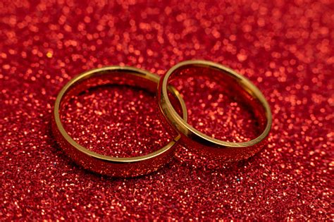 저와 결혼해 주시겠어요 붉은 반짝이 배경에 두 개의 황금 결혼 반지 약혼 결혼 제안 결혼식 개념입니다 성 발렌타인 데이 엽서 발렌타인 데이에 배너입니다 공간을 복사합니다 0