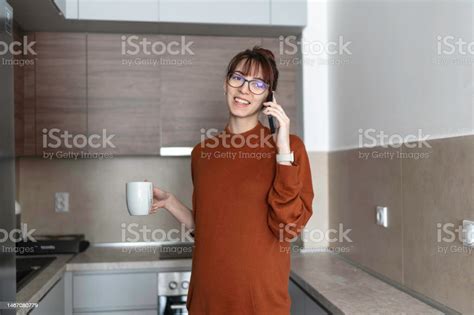 부엌에서 커피 한 잔을 들고 있는 쾌활한 임산부 아름다운 여자는 뜨거운 음료를 즐긴다 가정 생활에 대한 스톡 사진 및 기타 이미지 가정 생활 가정 주방 가정의 방