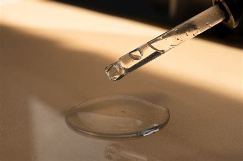 추상적인 그림자가 있는 베이지색 배경에 투명한 액체 화장품 질감이 있는 클로즈업 유리 스포이드 피부와 바디 케어 히알루 론산 건강관리와 의술에 대한 스톡 사진 및 기타