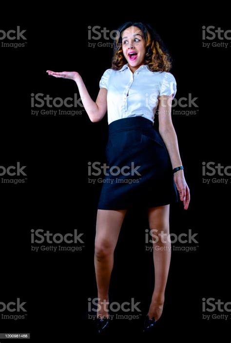 검은 배경에 제품을 발표 하는 젊은 비즈니스 여자 스튜디오에서 공간을 복사하는 여성 전문 포인팅 손의 초상화 제품을 제시 하는 미소 소녀 여성 모델 현재 빈 공간 갈색