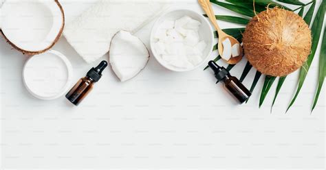 흰색 배경에 천연 코코넛 화장품 세트 코코넛 오일 핸드 크림 코코넛 하프 그릇에 강판 코코넛 열대 야자 잎 및 수건으로 평평한 누워 구성 스파 유기농 미용 제품