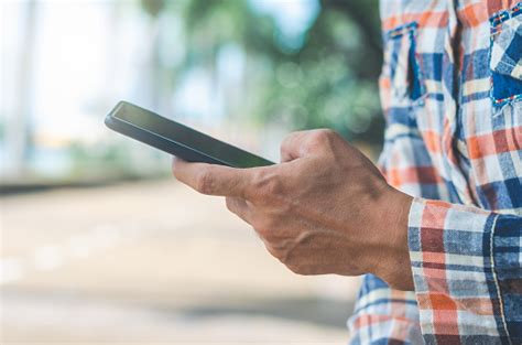 일출과 건물 배경과 도시에서 야외 응용 프로그램 장치와 손 타이핑 휴대 전화와 터치 스크린 작업 검색을 사용하여 잘 생긴 남자를 닫습니다 세계를 연결하는 5g 기술 5g에