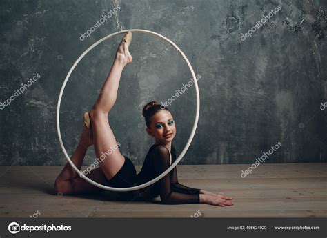 Молодая девушка профессиональная гимнастка танцует ритмическую гимнастику с обручем в студии