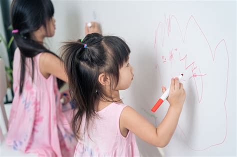 아시아의 젊은 형제 아이 소녀는 거실에서 흰색 벽에 페인트를 즐길 수 있습니다 재미있는 그림을 그리고 합창으로 예술 사진을 색칠하는 작은 사랑스러운 아이들은 집에서 휴가에