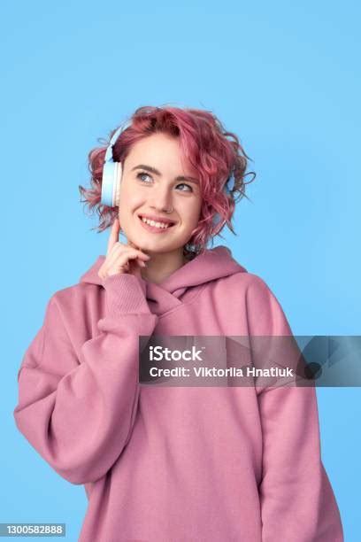Девушка С Розовыми Волосами В Толстовке И Наушниках Наслаждается Музыкой И Смотрит В Сторону