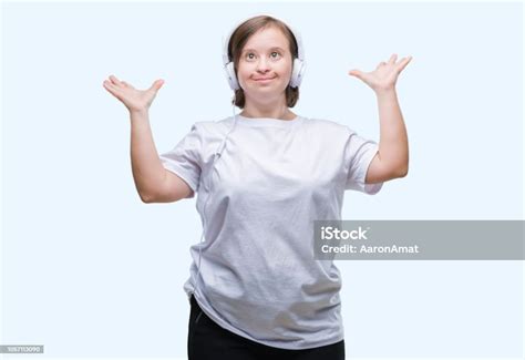 격리 된 배경 미친 미친 소리 고 적극적인 식와 팔 제기 함에 헤드폰을 착용 하는 다운 증후군 젊은 성인 여자 좌절 개념입니다